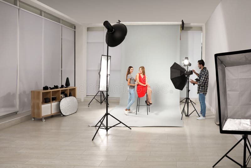 Professional Photographer and Assistant with Model in Modern Studio ...
