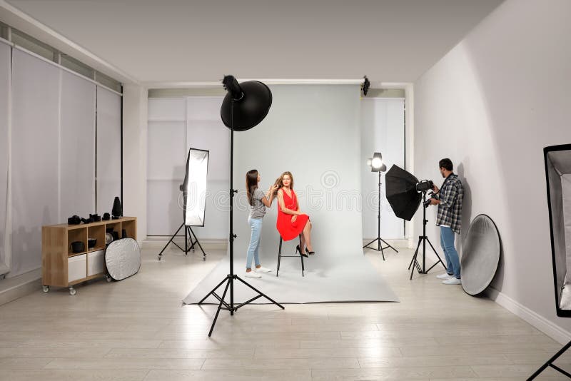 Professional Photographer and Assistant Working with Model in Studio ...