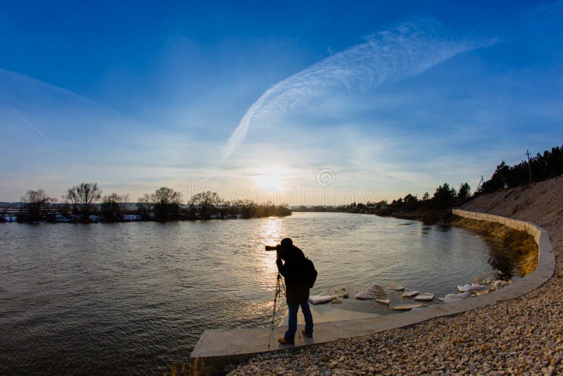 Professional Photographer Taking a Photo Flooding River at Sunset Stock ...