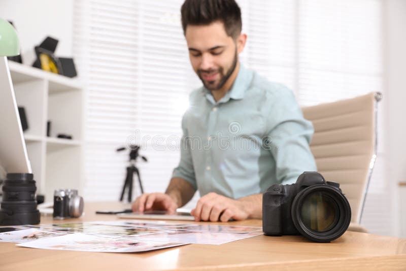 Professional Photographer Working at Table, Focus on Camera Stock Photo ...