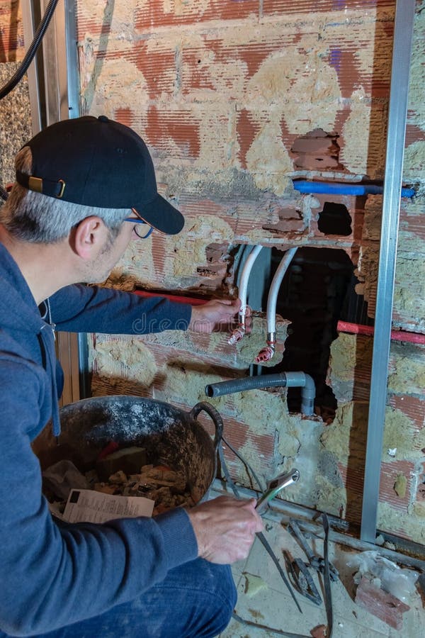 Professional Plumber Installing a Water Pipe System Inside an Exposed ...