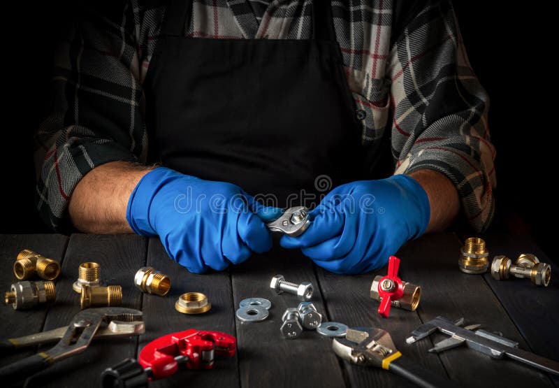 A Professional Plumber Tightens the Nut with a Wrench. Close-up of the ...
