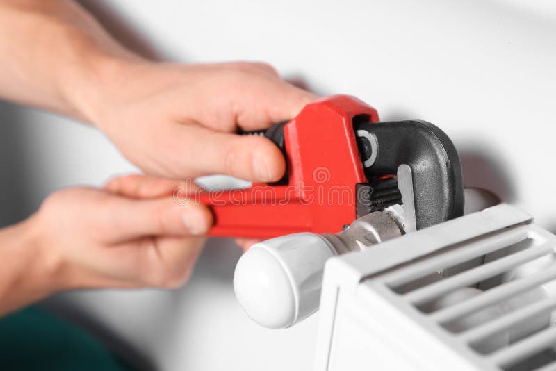Professional Plumber Using Adjustable Wrench for Installing New Heating ...