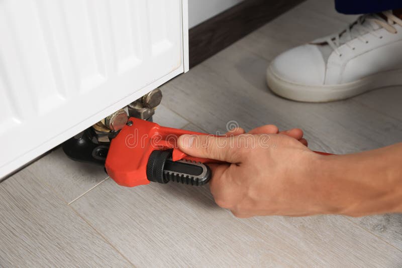 Professional Plumber Using Adjustable Wrench for Installing New Heating ...