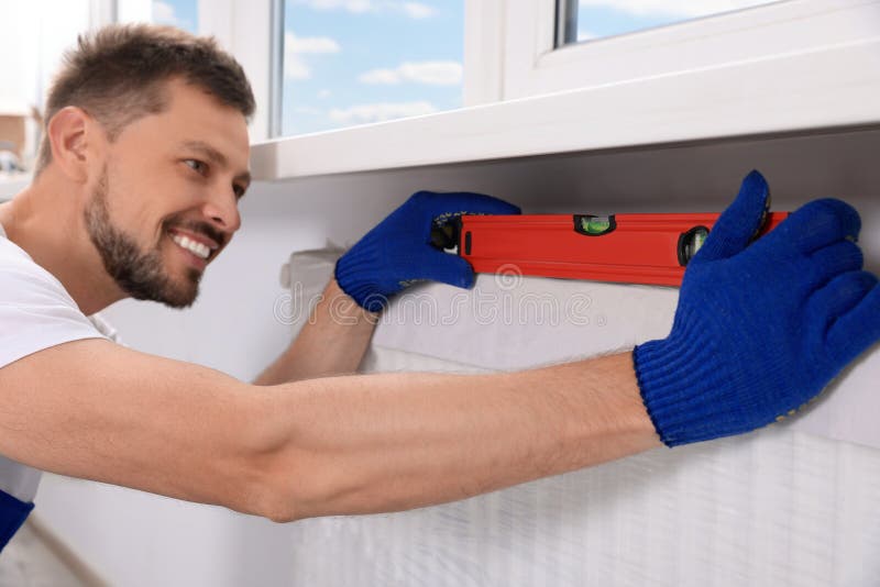 Professional Plumber Using Bubble Level for Installing New Heating ...