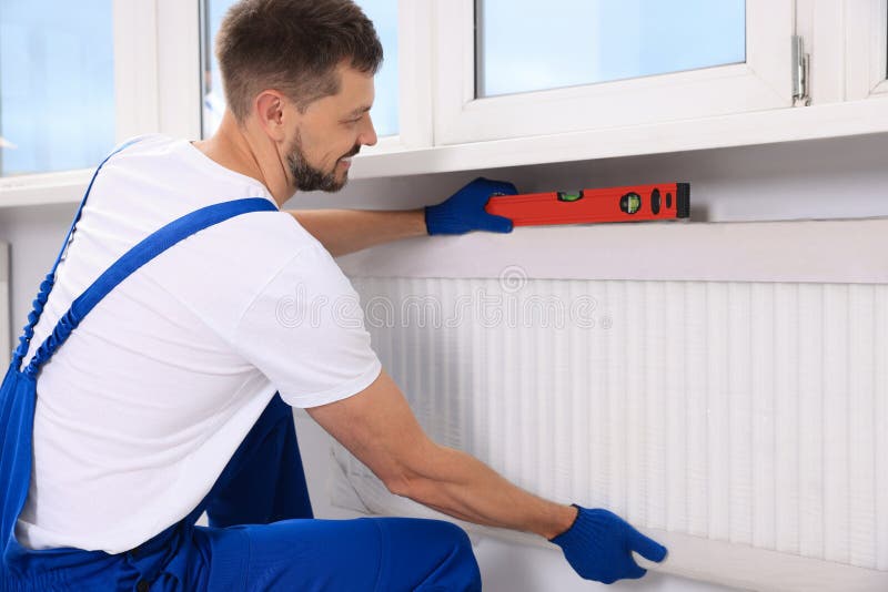 Professional Plumber Using Bubble Level for Installing New Heating ...