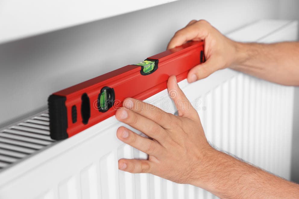 Professional Plumber Using Bubble Level for Installing New Heating ...