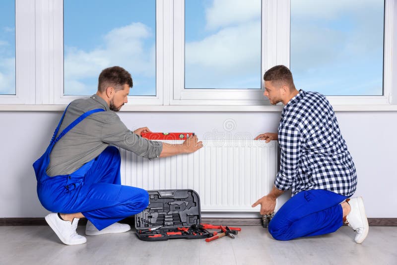 Professional Plumbers Using Bubble Level for Installing New Heating ...