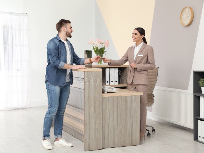 Professional Receptionist Working with Client at Desk in Hotel Stock ...