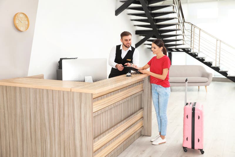 Professional Receptionist Working with Client at Desk in Hotel Stock ...
