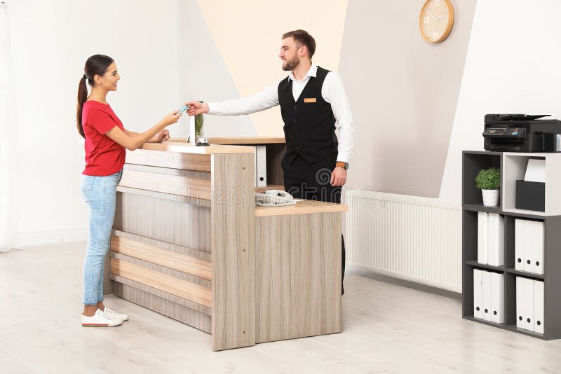 Professional Receptionist Working with Client at Desk Stock Photo ...