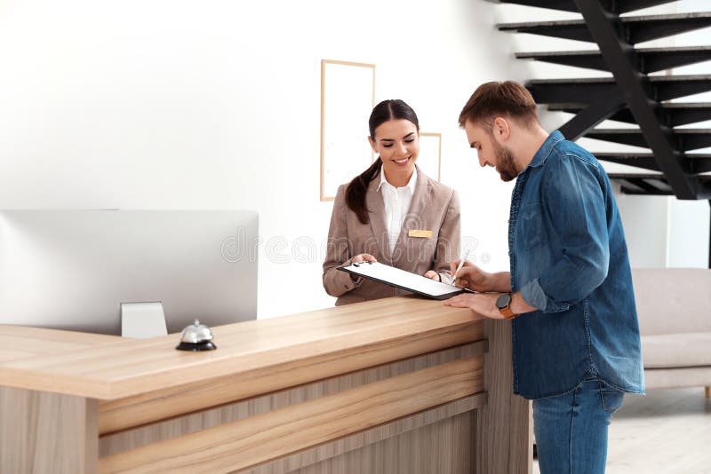 Professional Receptionist Working with Client at Desk Stock Image ...