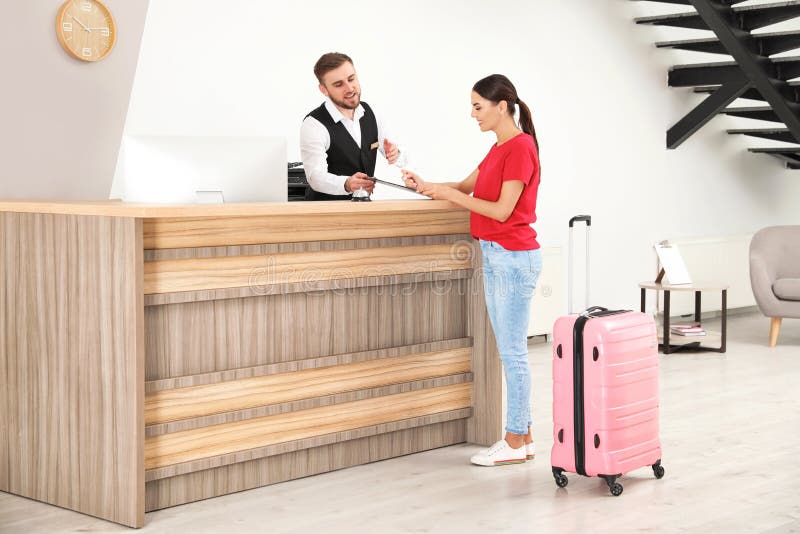 Professional Receptionist Working with Client at Desk in Hotel Stock ...