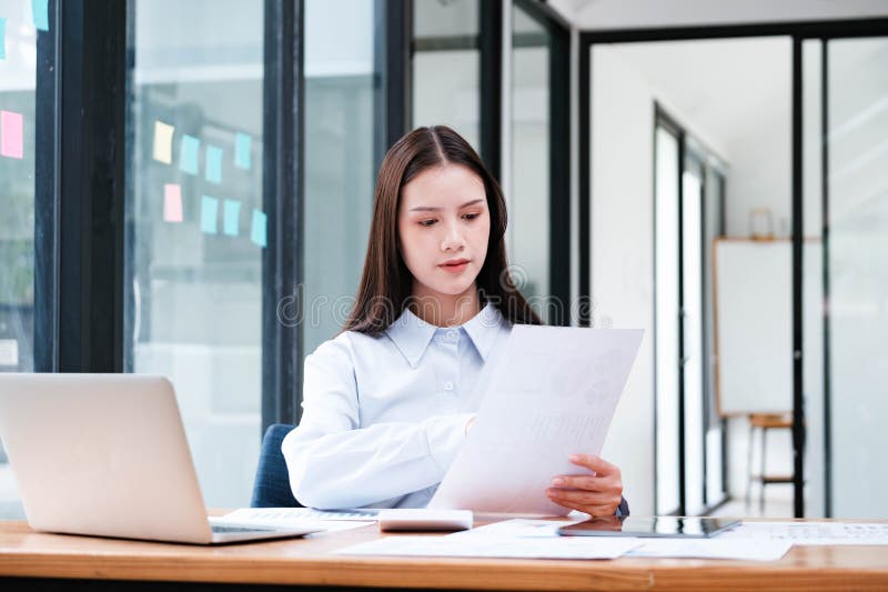 Professional Reviewing Documents and Analyzing Data in a Modern Office ...