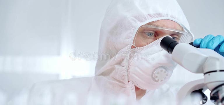 Professional Scientist in Protective Gear is Using Microscope in a ...