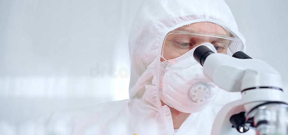 Professional Scientist in Protective Gear is Using Microscope in a ...