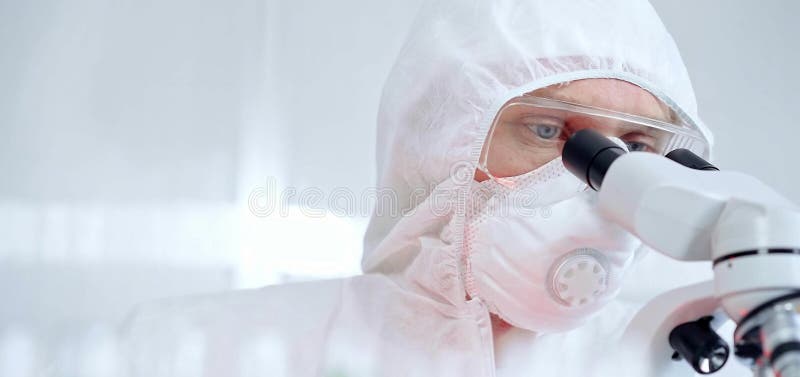 Professional Scientist in Protective Gear is Using Microscope in a ...