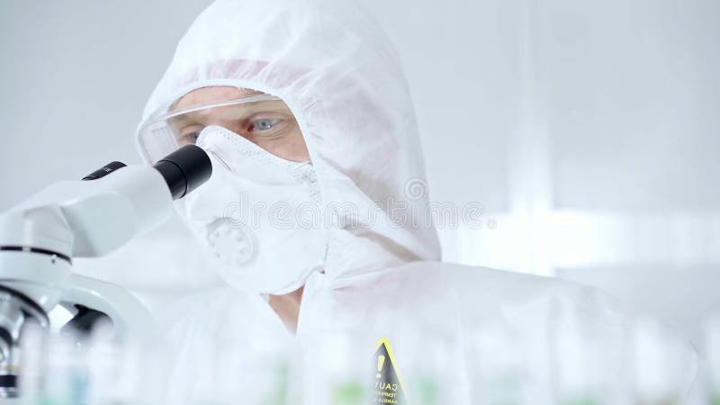 Professional Scientist in Protective Gear is Using Microscope in a ...