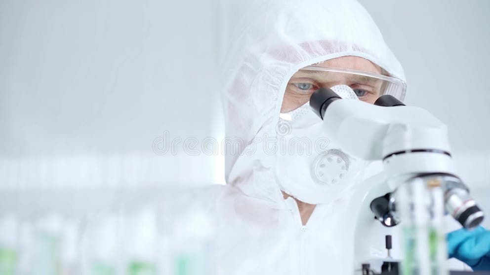 Professional Scientist in Protective Gear is Using Microscope in a ...