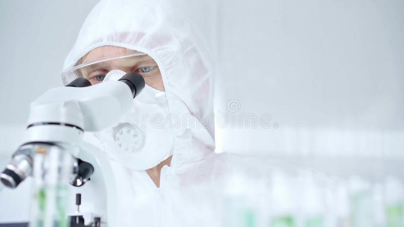 Professional Scientist in Protective Gear is Using Microscope in a ...