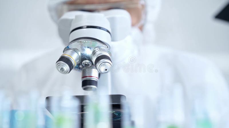 Professional Scientist in Protective Gear is Using Microscope in a ...
