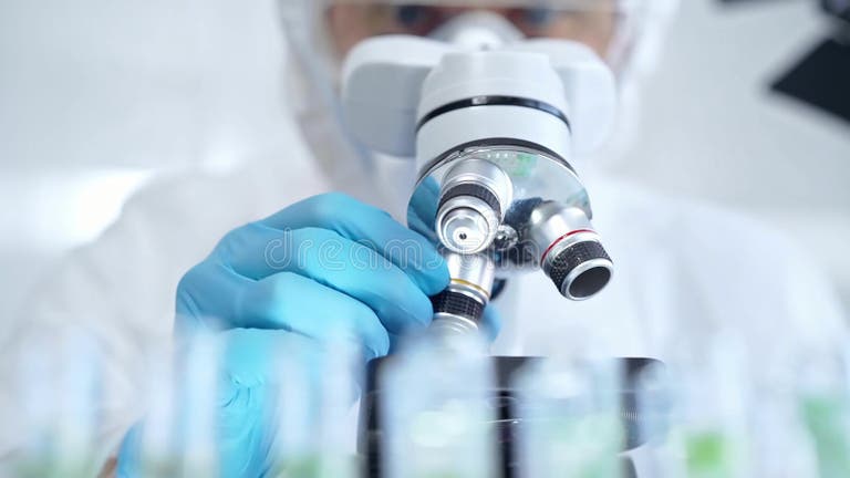 Professional Scientist in Protective Gear is Using Microscope in a ...