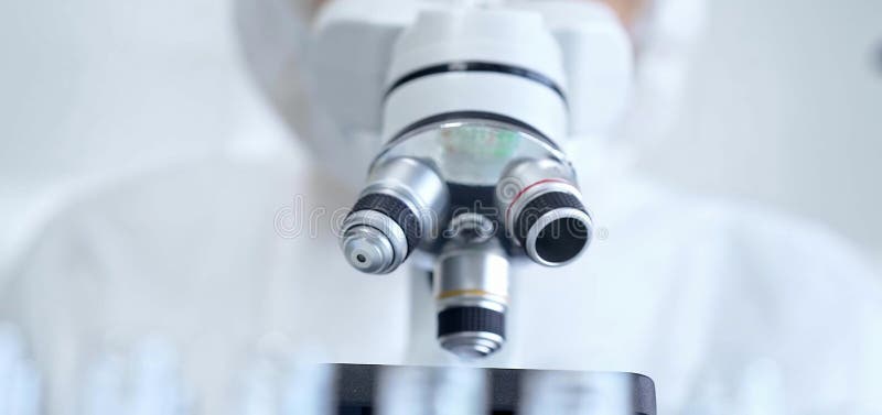 Professional Scientist in Protective Gear is Using Microscope in a ...