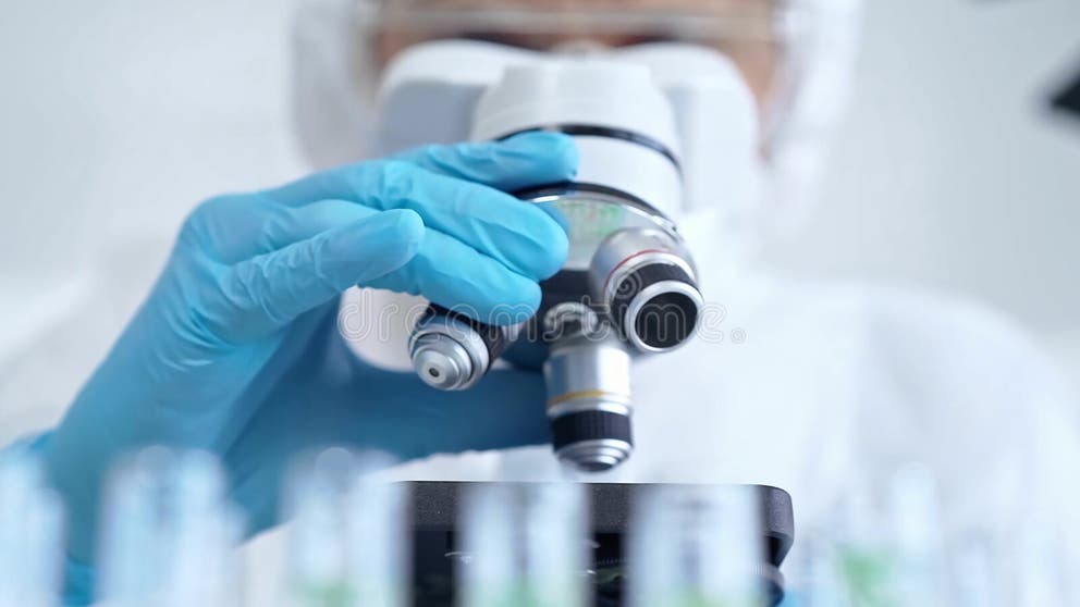 Professional Scientist in Protective Gear is Using Microscope in a ...