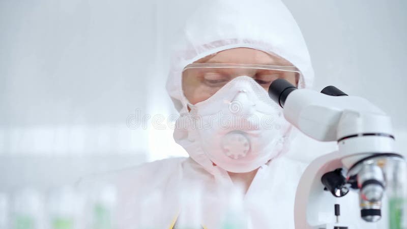 Professional Scientist in Protective Gear is Using Microscope in a ...