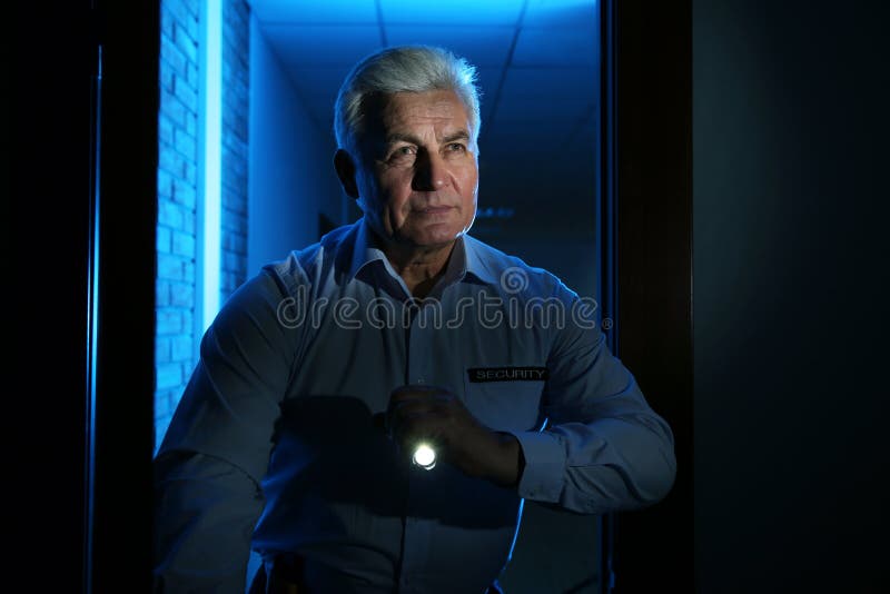 Professional Security Guard with Flashlight Checking Dark Room Stock ...