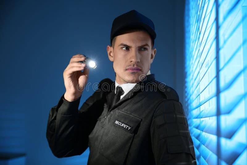 Professional Security Guard with Flashlight Near Window in Room Stock ...