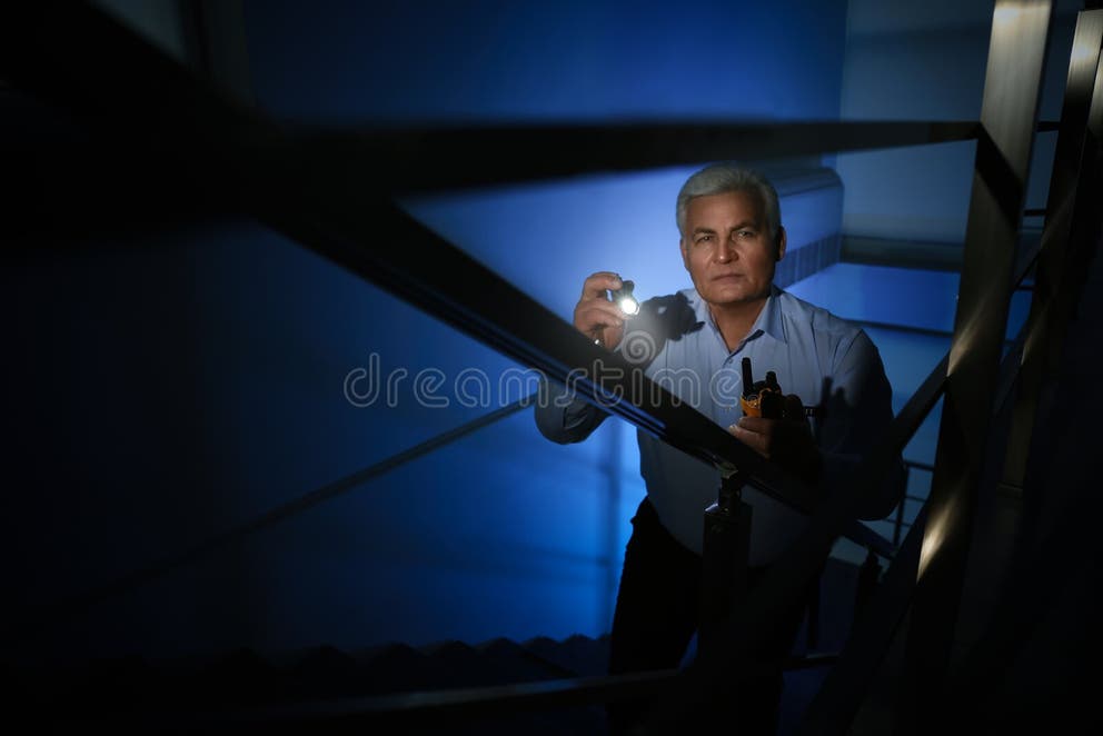 Professional Security Guard with Flashlight on Stairs in Room Stock ...
