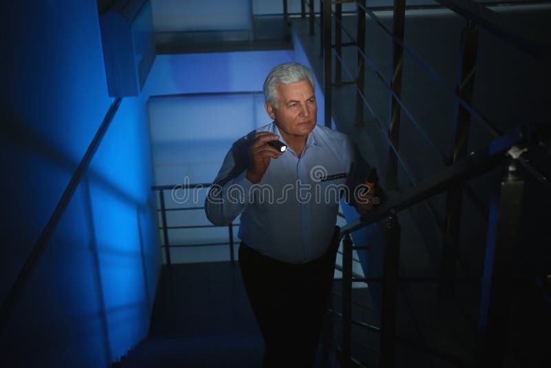 Professional Security Guard with Flashlight on Stairs in Room Stock ...