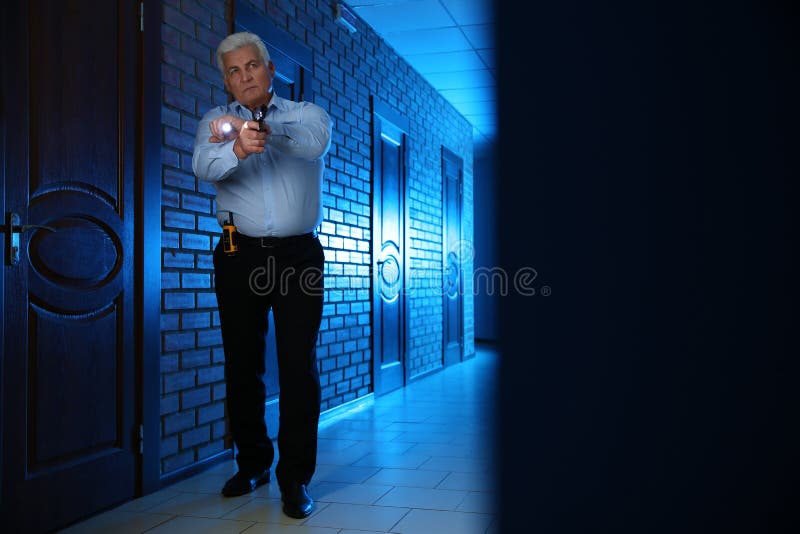 Professional Security Guard with Gun and Flashlight Checking Hallway ...