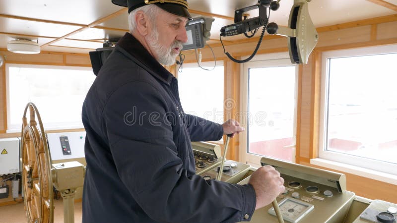 Professional Senior Captain in Wheelhouse Operates the Ship Using Two ...