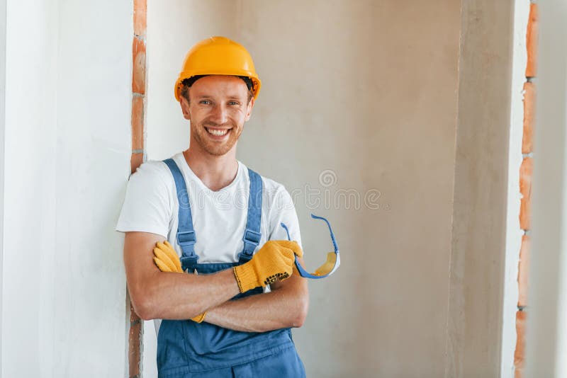 Professional Service. Young Man Working in Uniform at Construction at ...