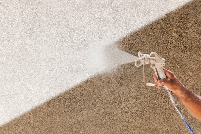 Spray Painter Holding Spray Gun Spraying White Paint Over Brown Stucco ...