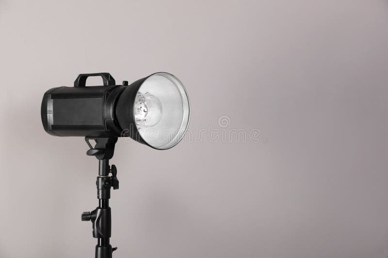 Professional Studio Flash Light with Reflector on Tripod Against Grey ...