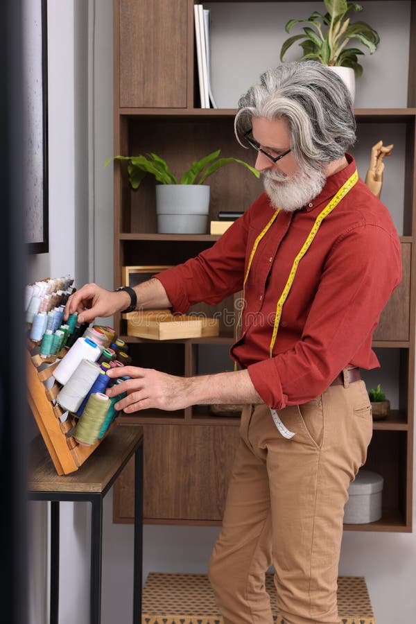 Professional Tailor Choosing Thread Near Stand in Workshop Stock Photo ...