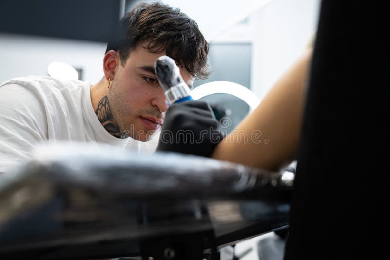 Professional Tattoo Artist with Focus and Precision, Applying a Tattoo ...