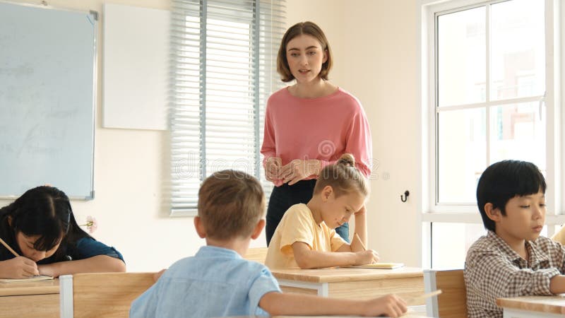 Professional Teacher Explain Classwork To Caucasian Boy at Classroom ...