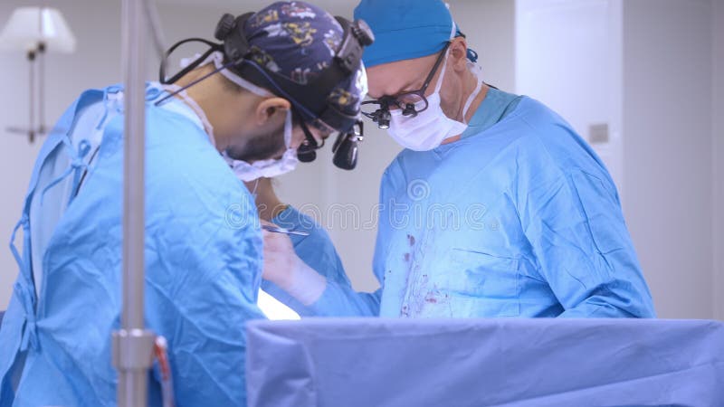 A Professional Team of Doctors, Surgeons and Nurses Perform Surgery on ...