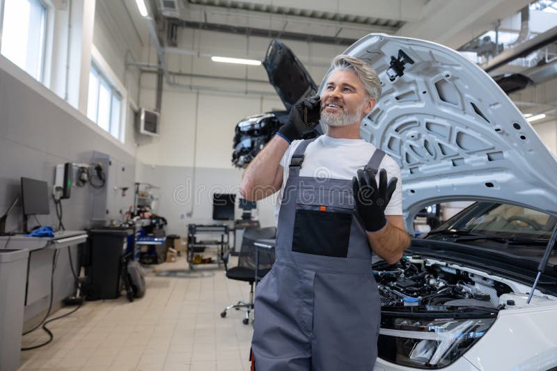 Professional Technician Car Mechanic Man in Overalls Using Mobile Cell ...
