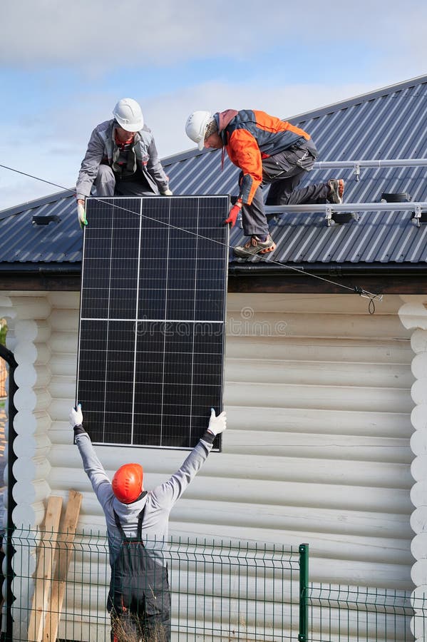 Professional Technicians Lifting Solar Panels on a Roof of House Stock ...
