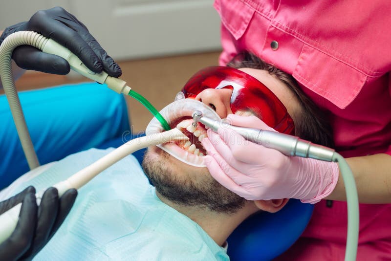 Professional Teeth Cleaning. Dentist Cleans the Teeth of a Male Patient ...