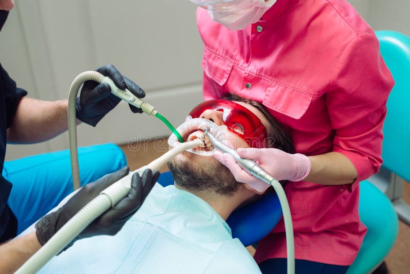 Professional Teeth Cleaning. Dentist Cleans the Teeth of a Male Patient ...