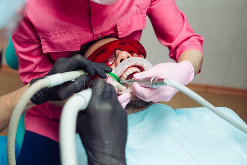 Professional Teeth Cleaning. Dentist Cleans the Teeth of a Male Patient ...