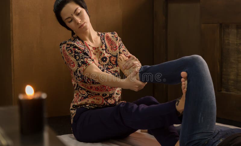 Professional Therapist Giving Traditional Thai Massage Or Thai Yoga