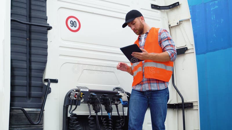 Professional Truck Driver Checking Using Tablet Computer and Standing ...