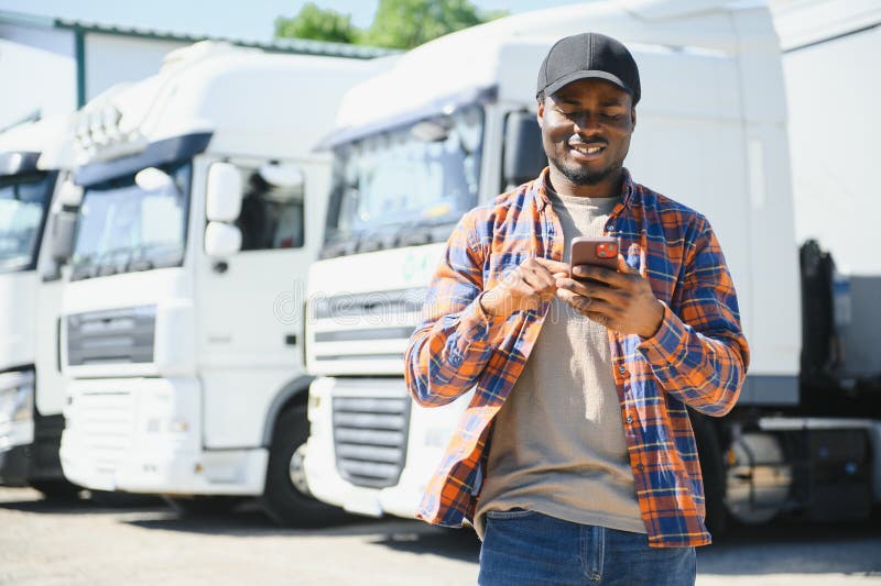 Professional Truck Driver Holding Smart Phone in Front of the Trucks ...